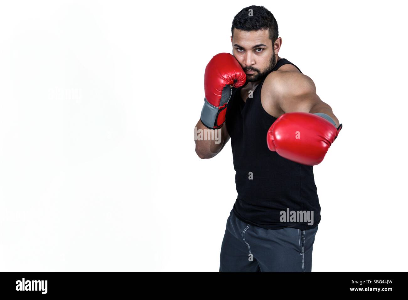 Male boxer throwing straight punch in studio against white backdrop ...