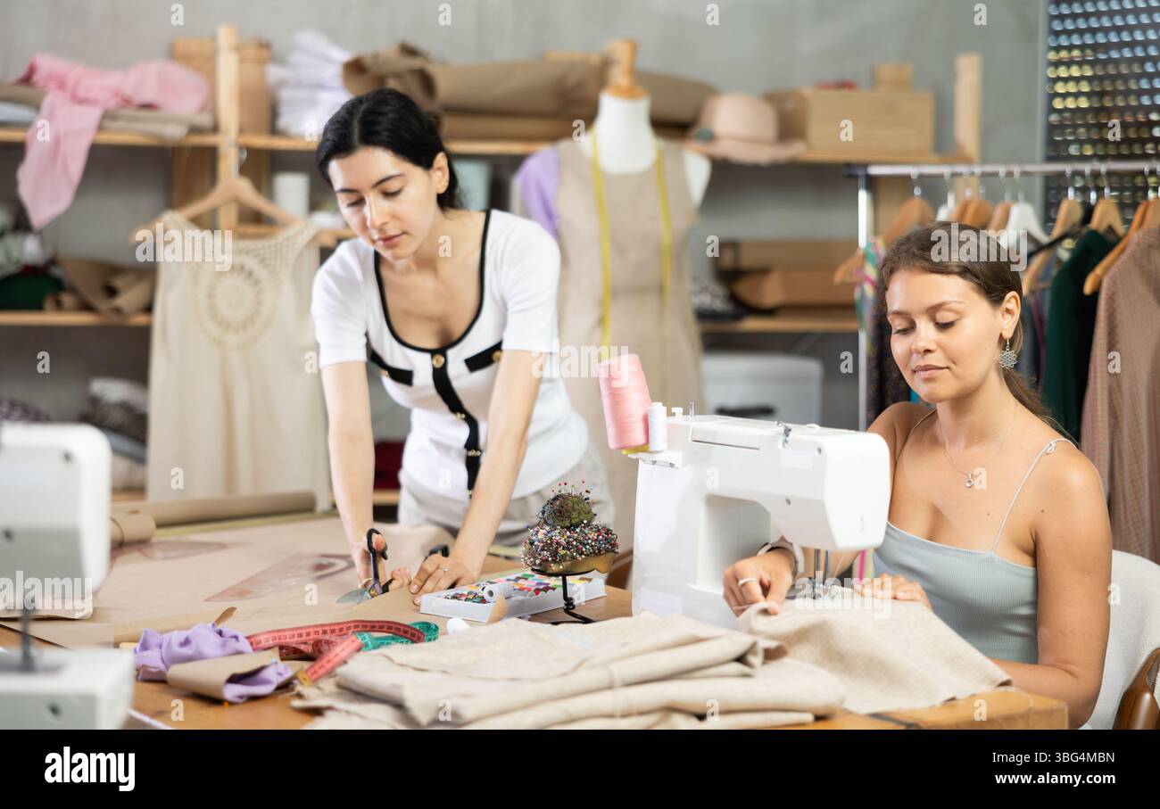 Two female tailors working on custom garment in studio Stock Photo - Alamy