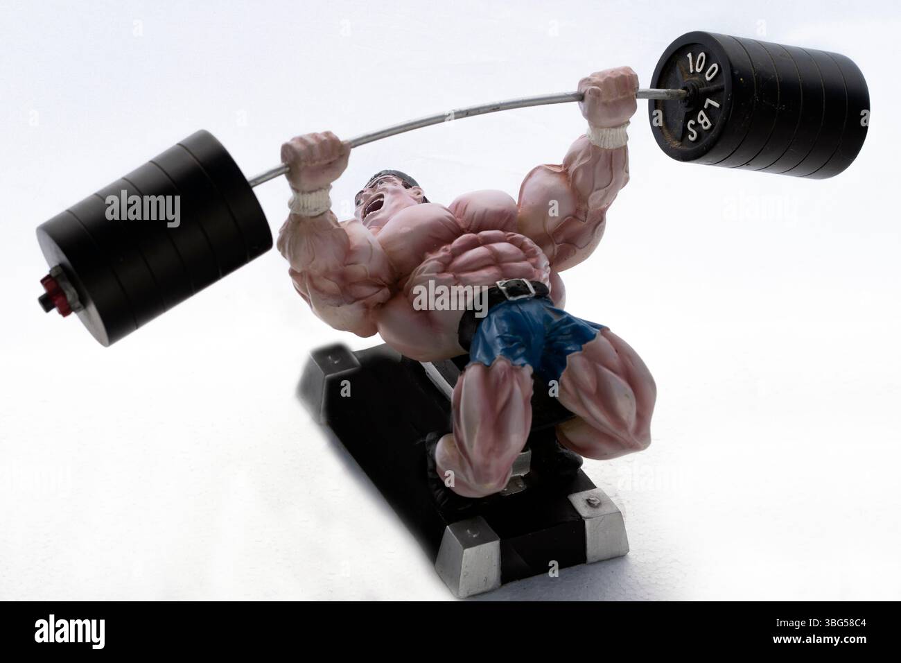 Powerful bodybuilding figurine lifting a 100lb barbell on a white ...