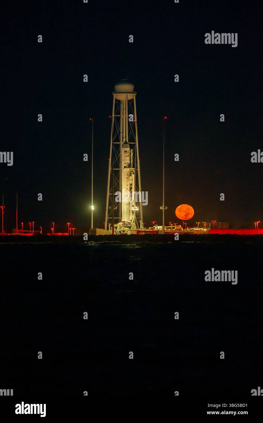 Antares rocket on launch pad with full Harvest Moon rising in the ...