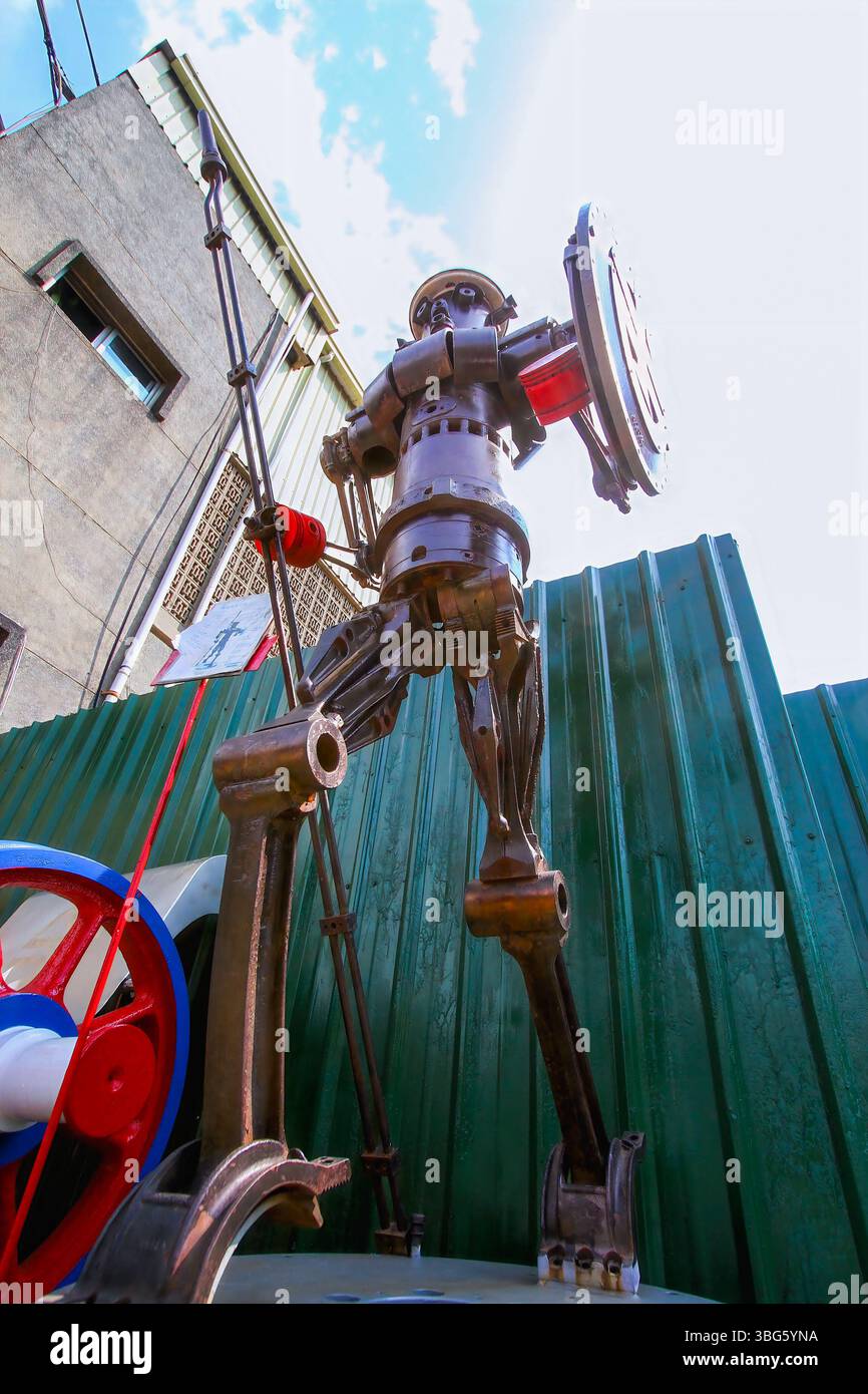A unique robot sculpture, crafted from recycled train parts, stands ...