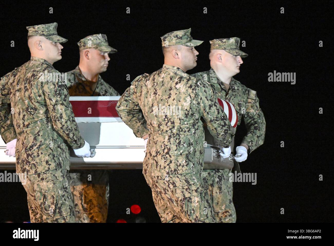 A Navy carry team moves a transfer case containing the remains of ...