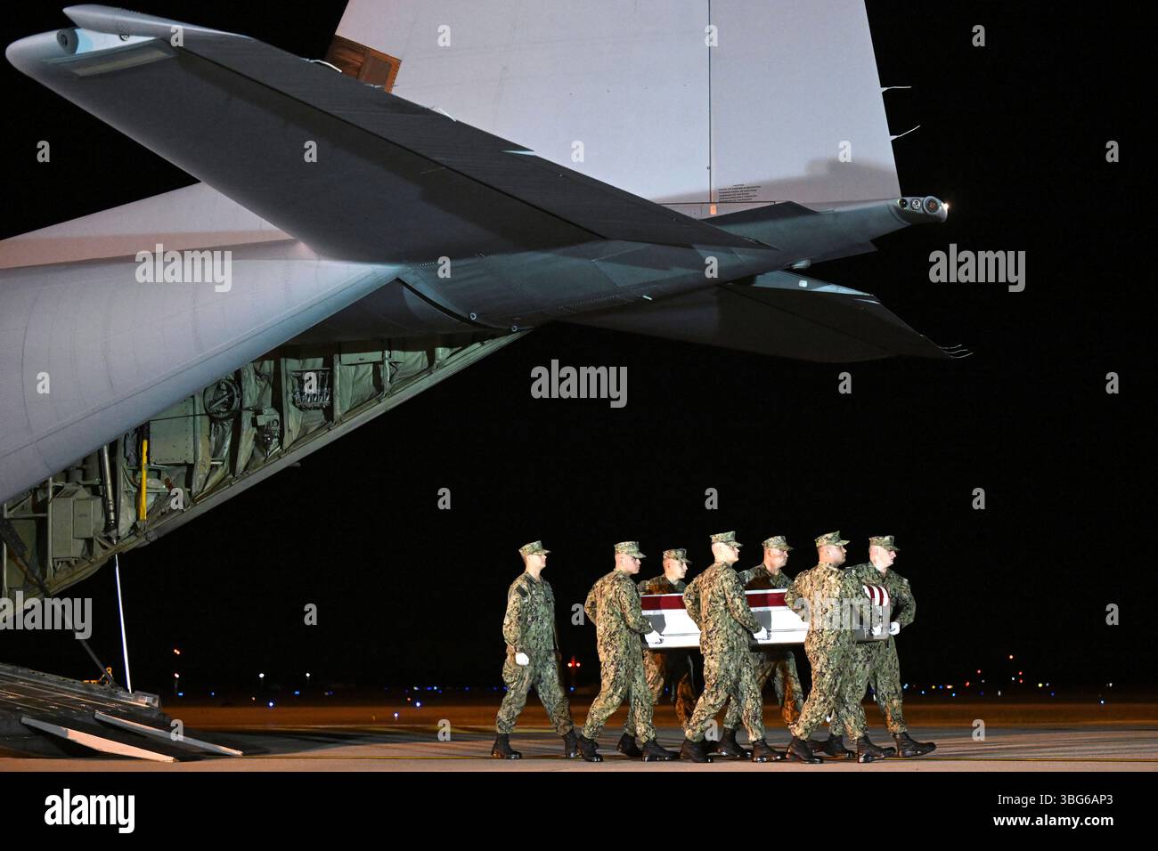 A Navy carry team moves a transfer case containing the remains of ...