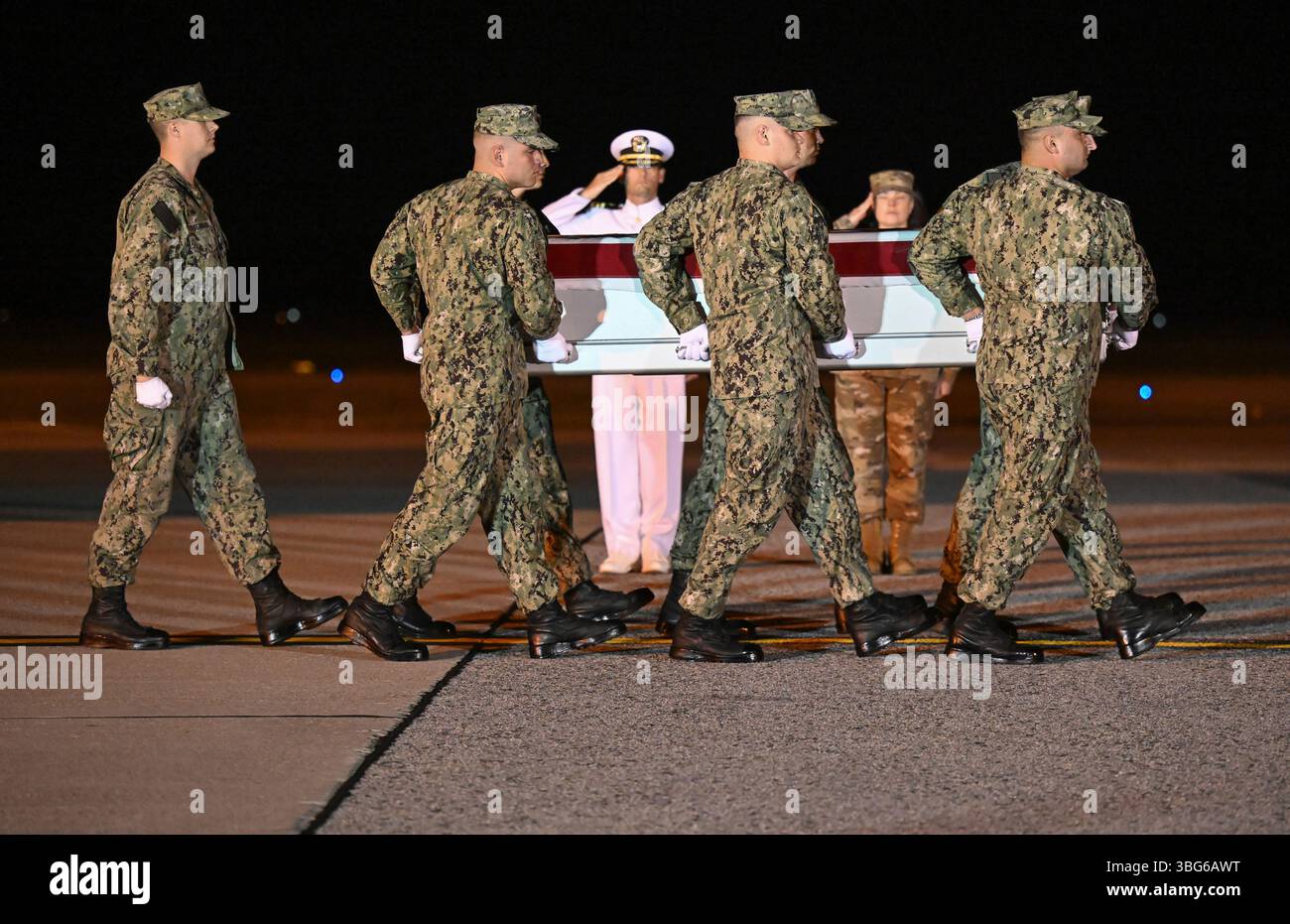 A Navy carry team moves a transfer case containing the remains of ...