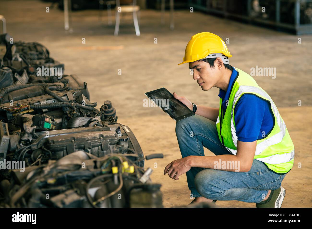 technician male worker working in scrapyard finding used car engine ...