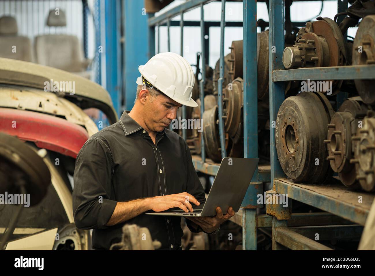 Old used car part warehouse worker checking inventory in garage. Staff ...