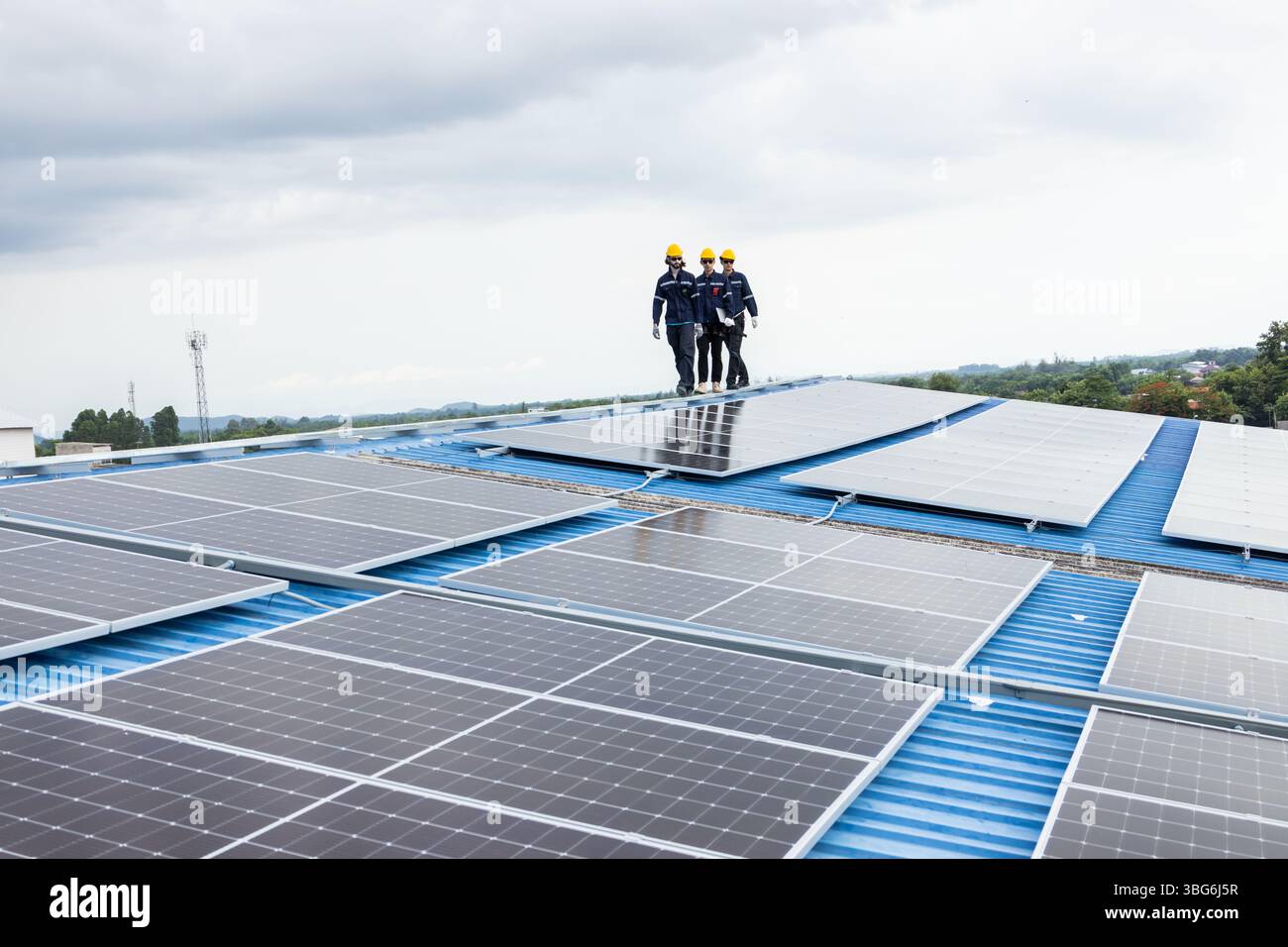 Worker walking inspection solar panels on the roof top of industry ...