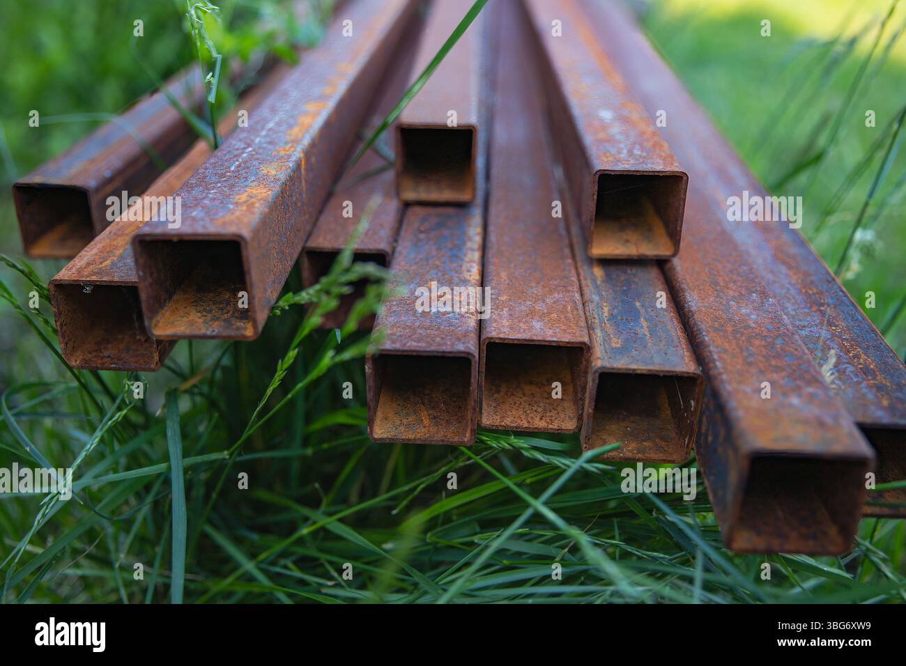 Rusty Steel Square Tubes on Grass, Industrial Background Stock Photo ...