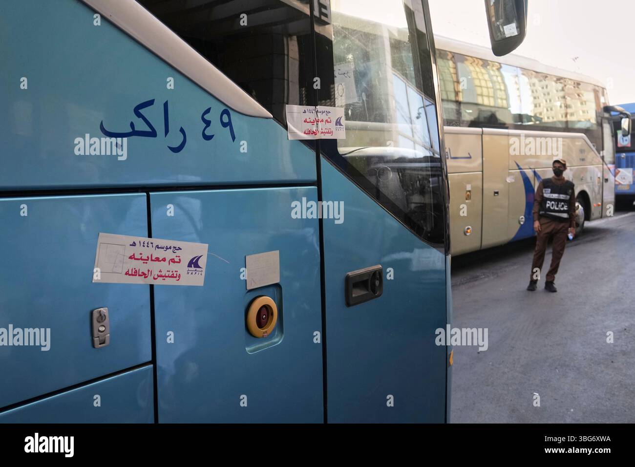 A Saudi policeman watches buses carrying pilgrims traveling from Mecca ...