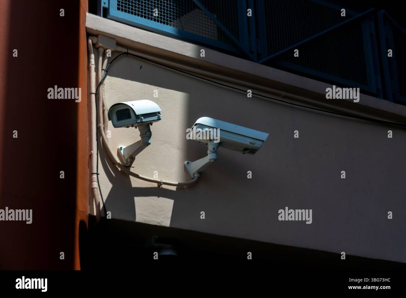 Two surveillance cameras mounted on a building provide security and ...
