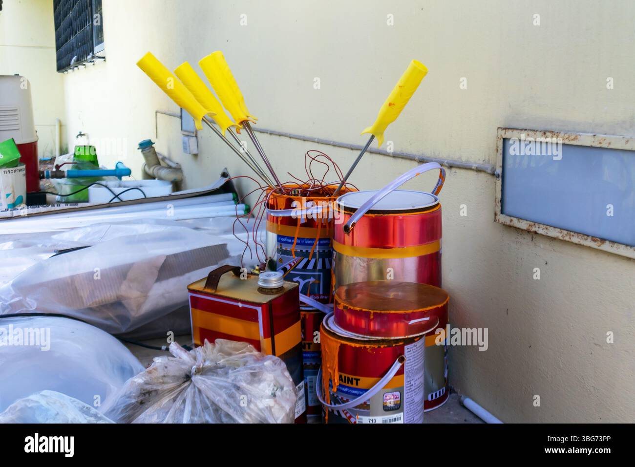 A vibrant assortment of paint cans and tools on a surface, showcasing ...