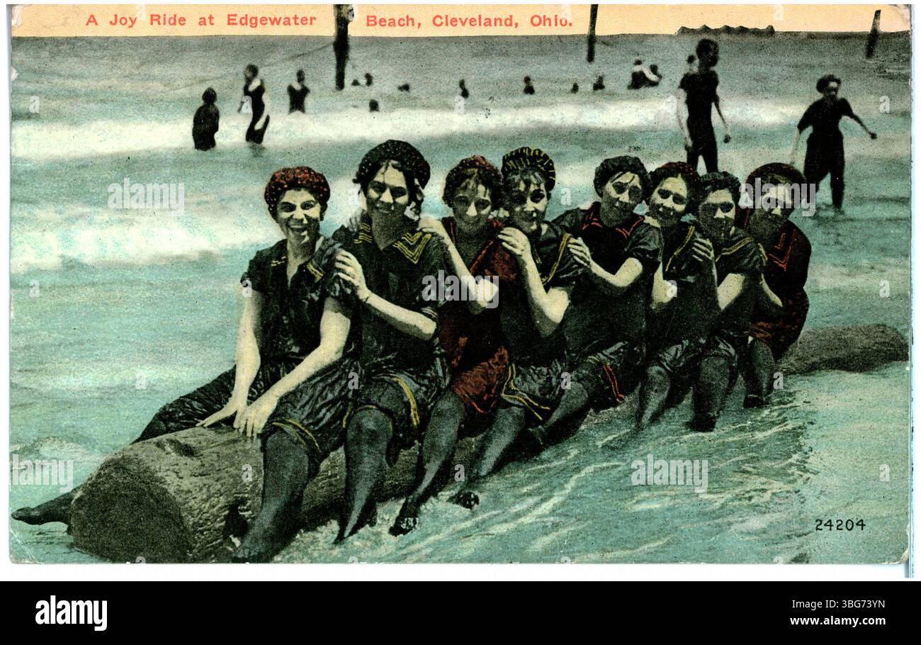 This 1912 colored photograph depicts swimmers riding a log at Edgewater ...