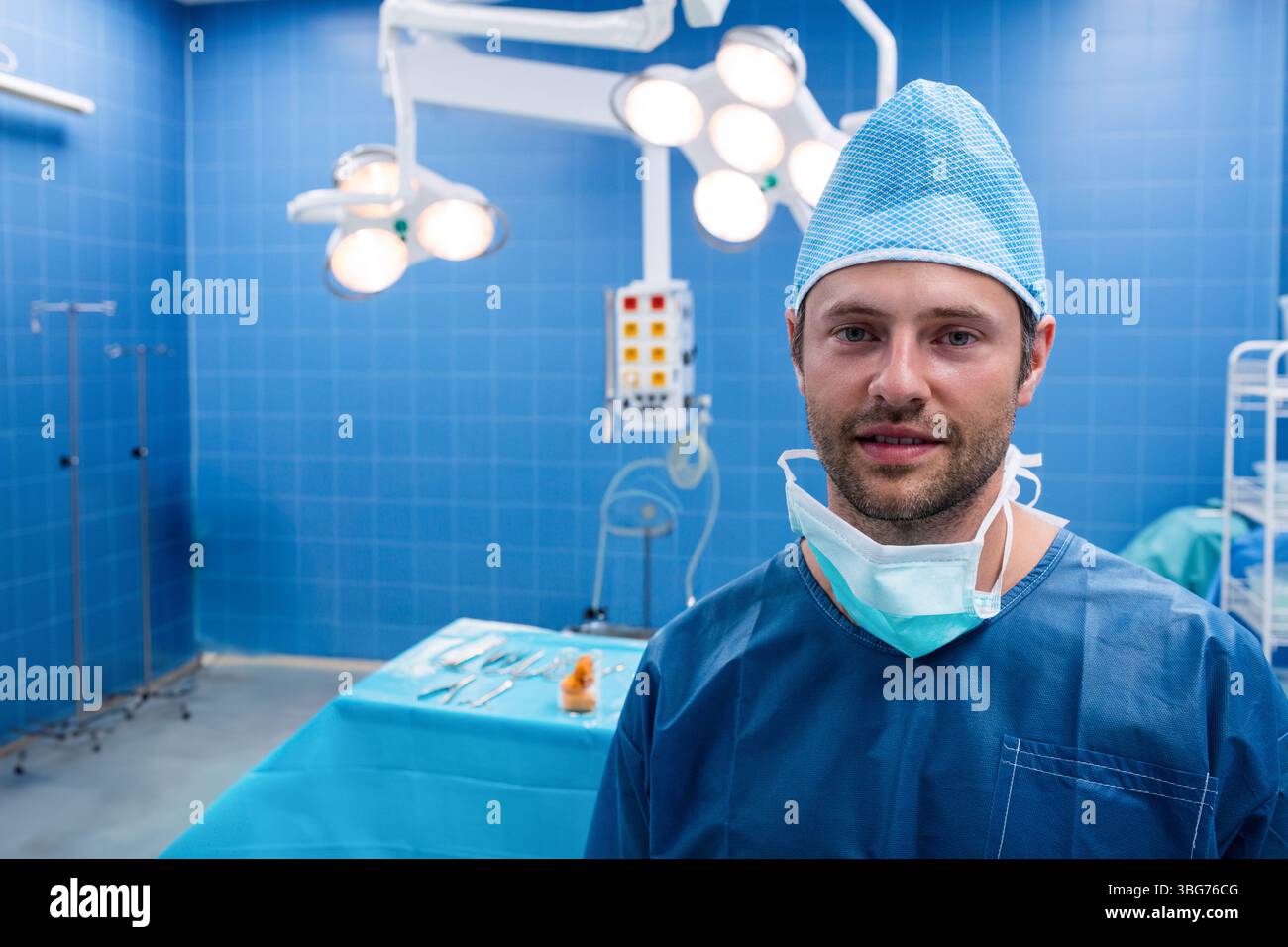 Surgical lights casting glow on instrument table with blue drape and IV ...