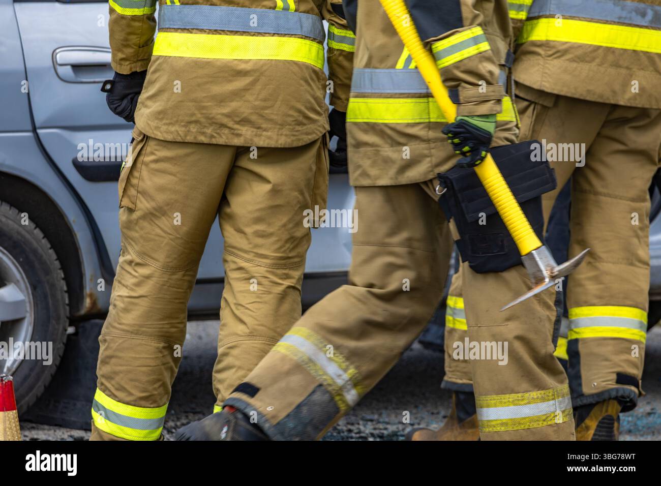 Firefighters wearing protective suits pulling a wounded man out of a ...