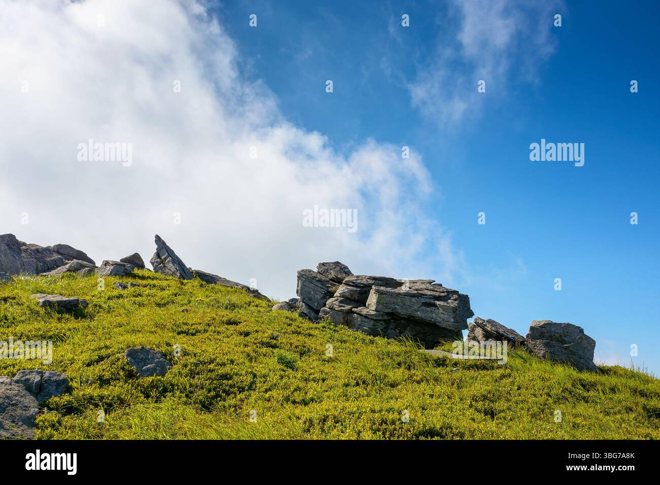 boulder on a hill under blue sky with clouds in summer. huge sandstone ...
