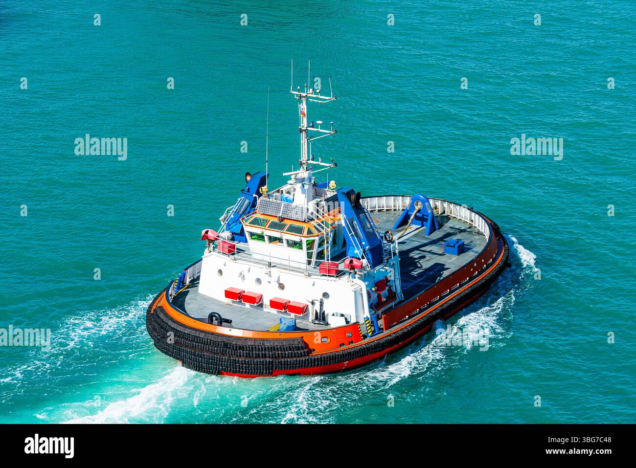 Modern tugboat in blue water, rear view Stock Photo - Alamy