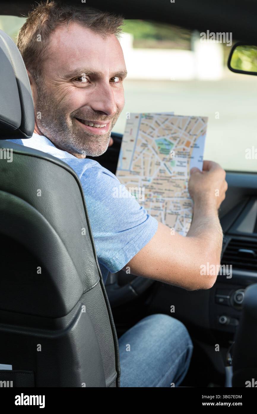 happy man with the map in the car Stock Photo - Alamy