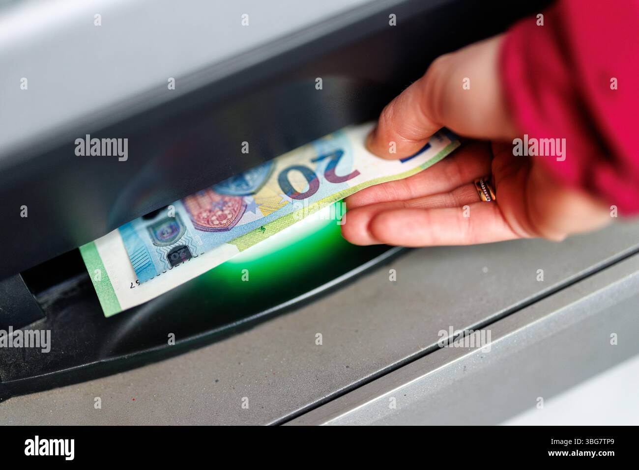 Munich, Germany. 29th May, 2025. A woman takes euro banknotes from an ...
