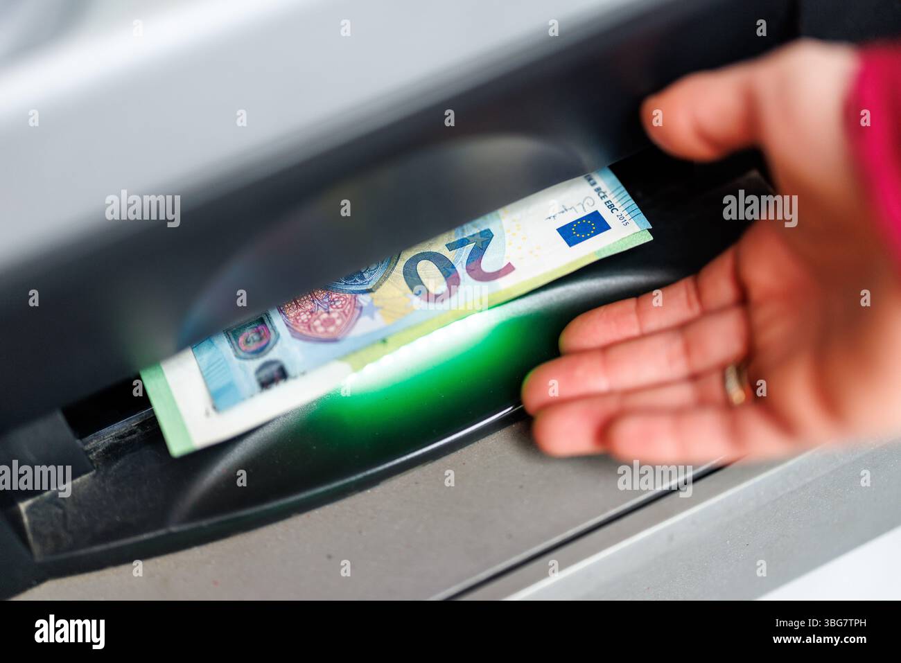 Munich, Germany. 29th May, 2025. A woman takes euro banknotes from an ...