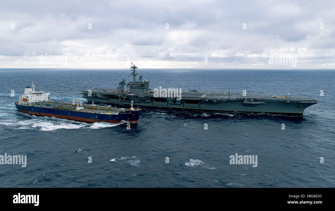 Military Sealift Command chartered ship motor tanker Badlands Trader positions alongside Nimitz ...