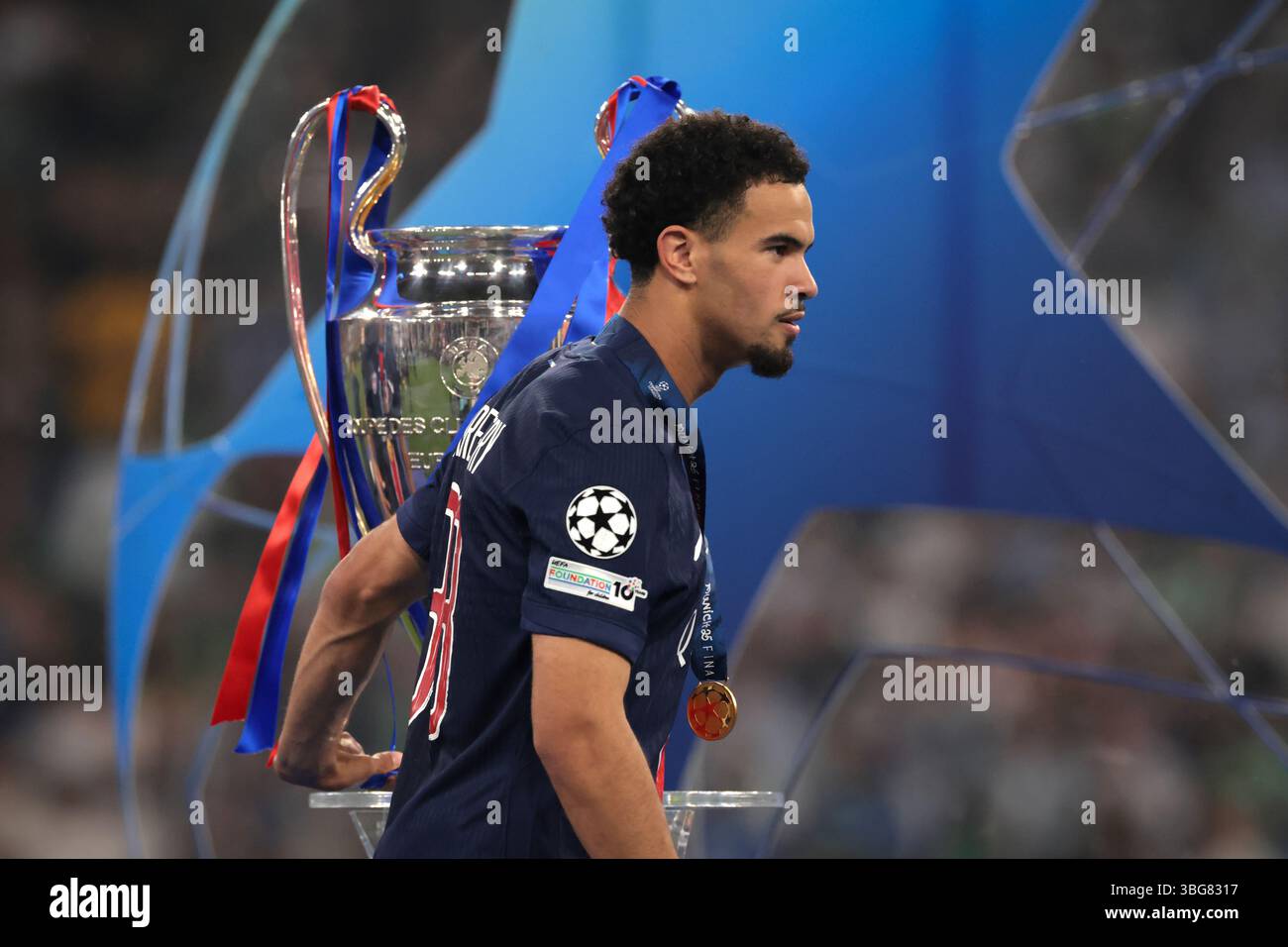 Munich, Germany. 31st May, 2025. Warren Zaire-Emery of PSG passes the trophy following the 5-0 ...