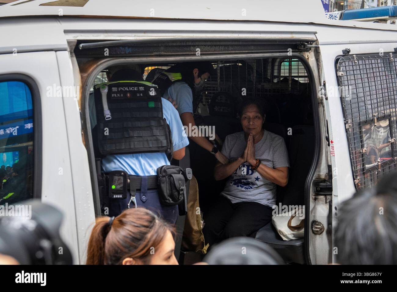 Activist Lui Yuk-lin, center, is detained by police officers in the ...