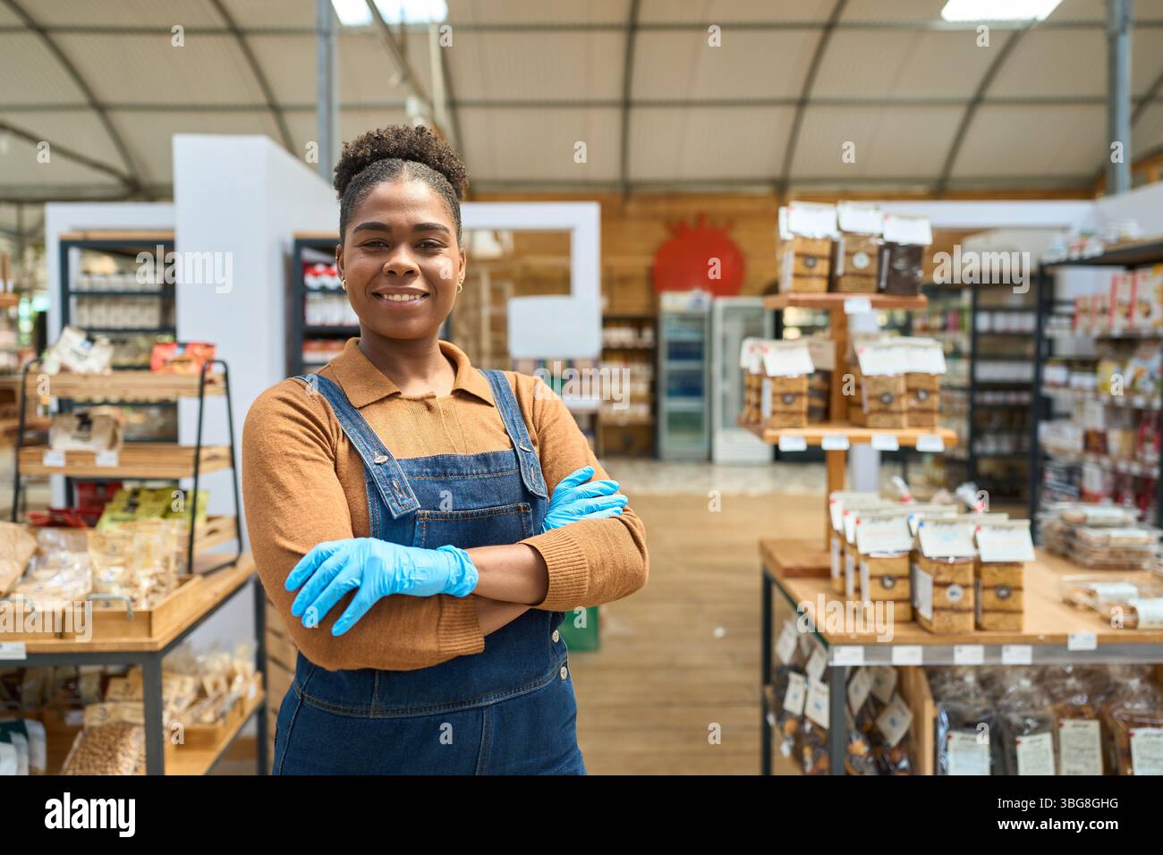 Confident african american saleswoman smiling with crossed arms in zero ...