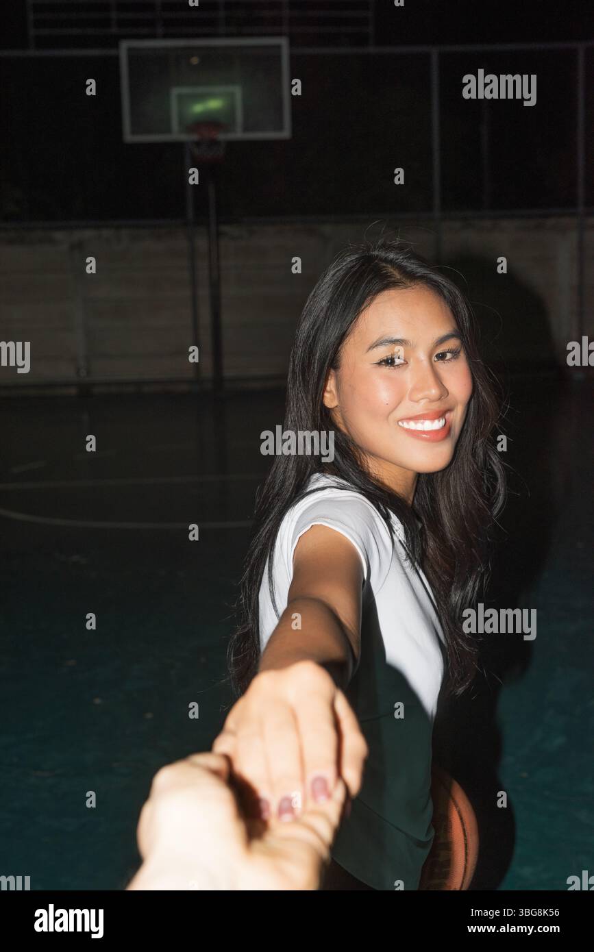 Young beautiful woman at night in basketball court posing Stock Photo ...
