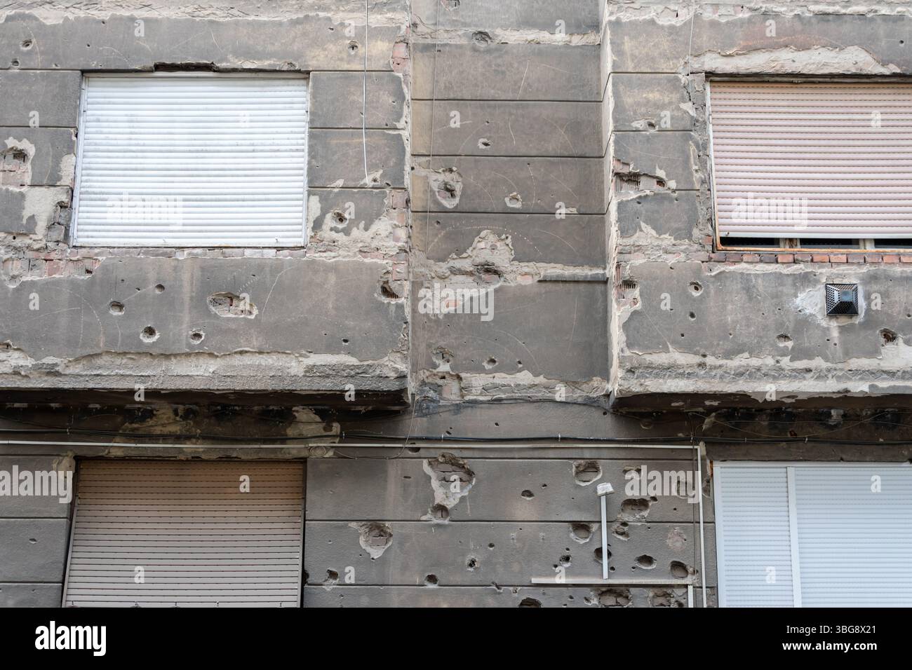 The façade of an old building, mottled with numerous bullet and ...