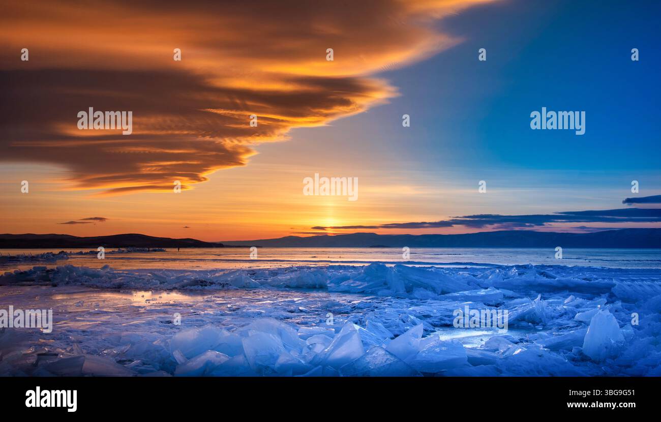 Sunset sky with natural breaking ice over frozen water on Lake Baikal ...