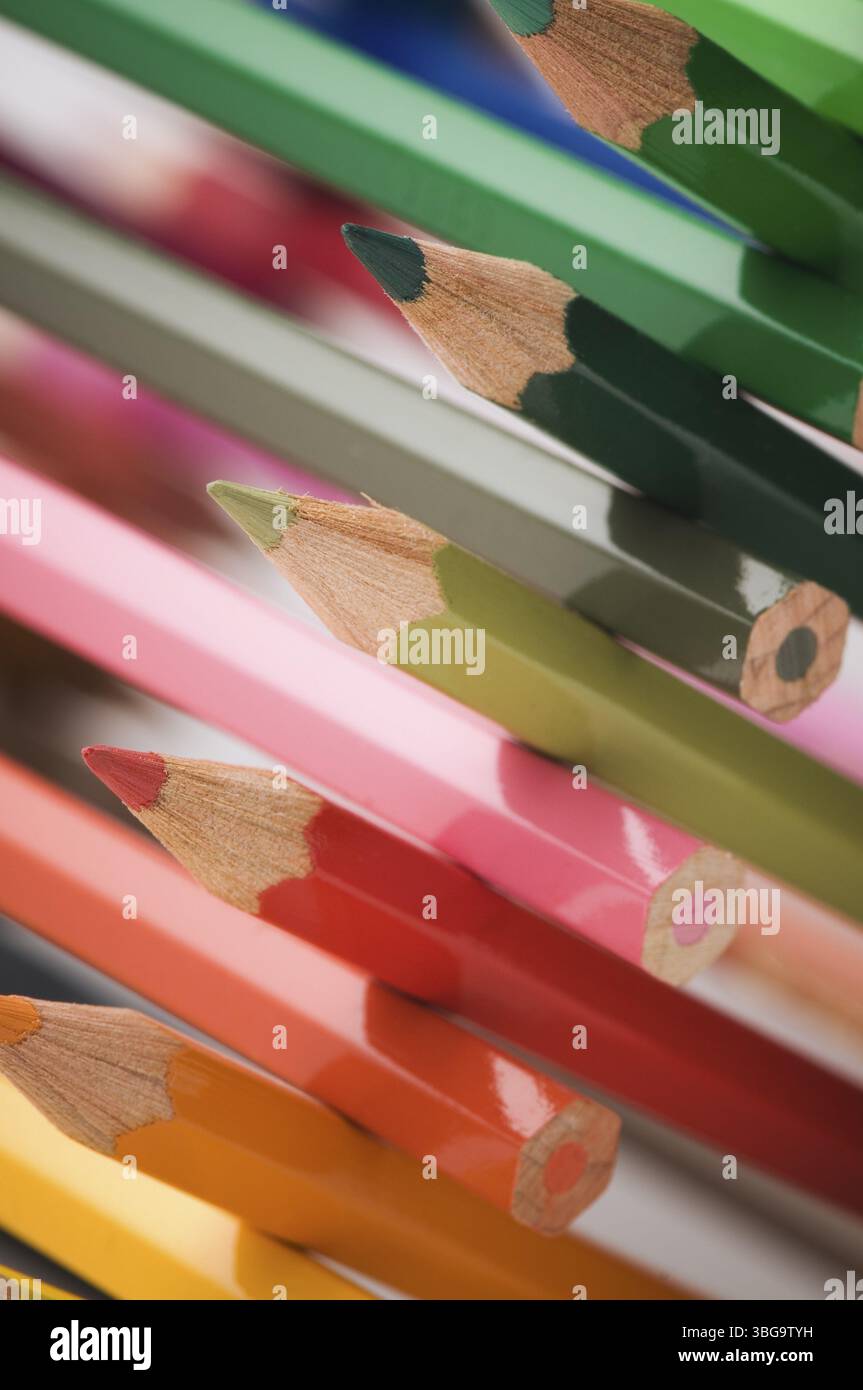 Close-up oblique view of crayons stacked crosswise in the colours of ...