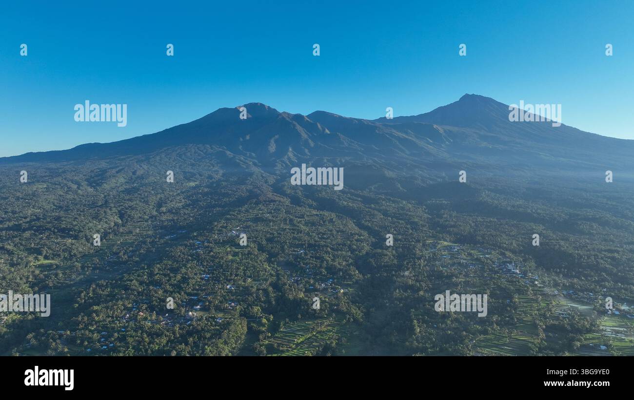 Mount Rinjani volcano dominates the horizon, its dramatic slopes ...