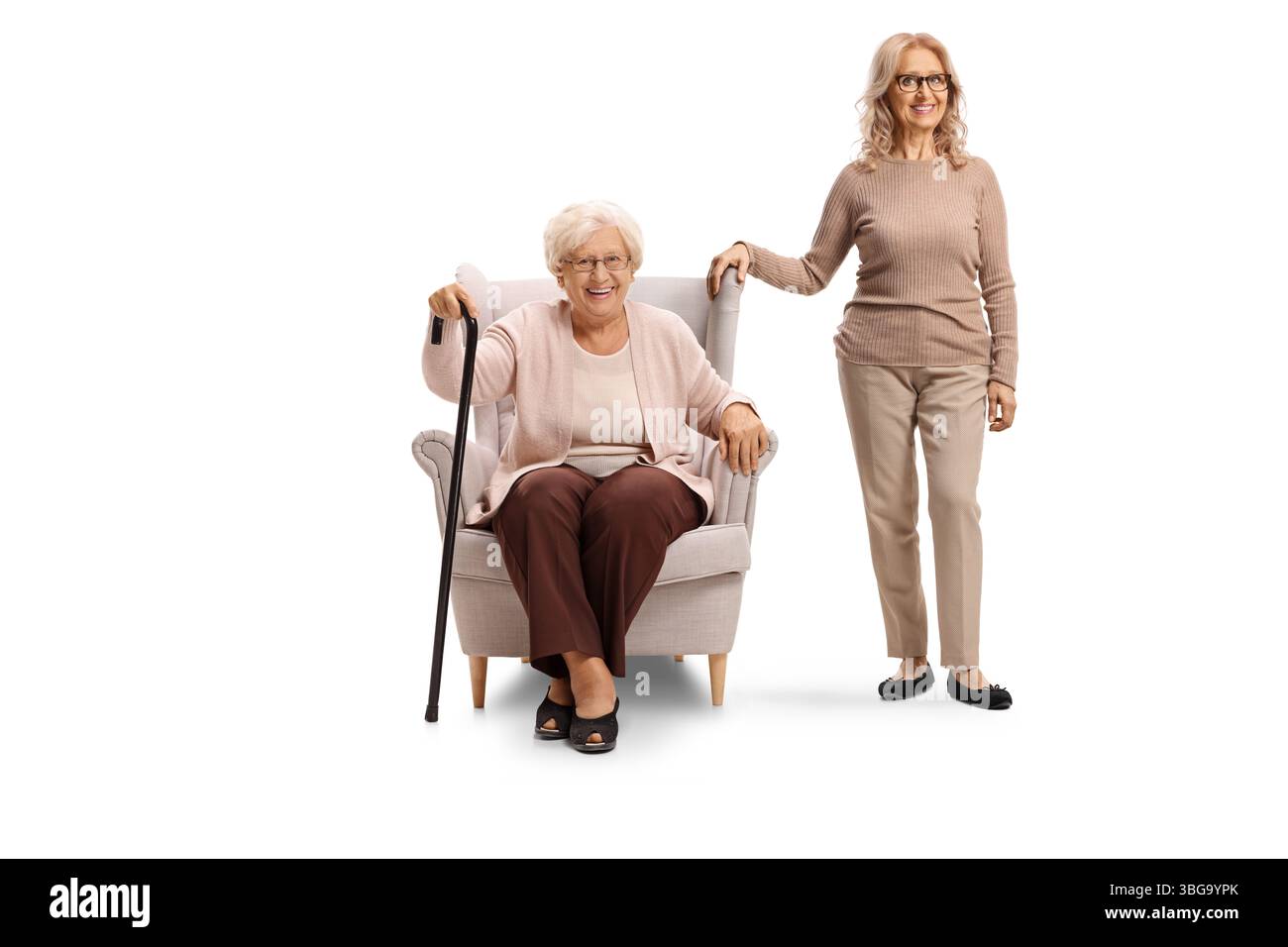 Woman standing next to a lady in an armchair, support and care for ...