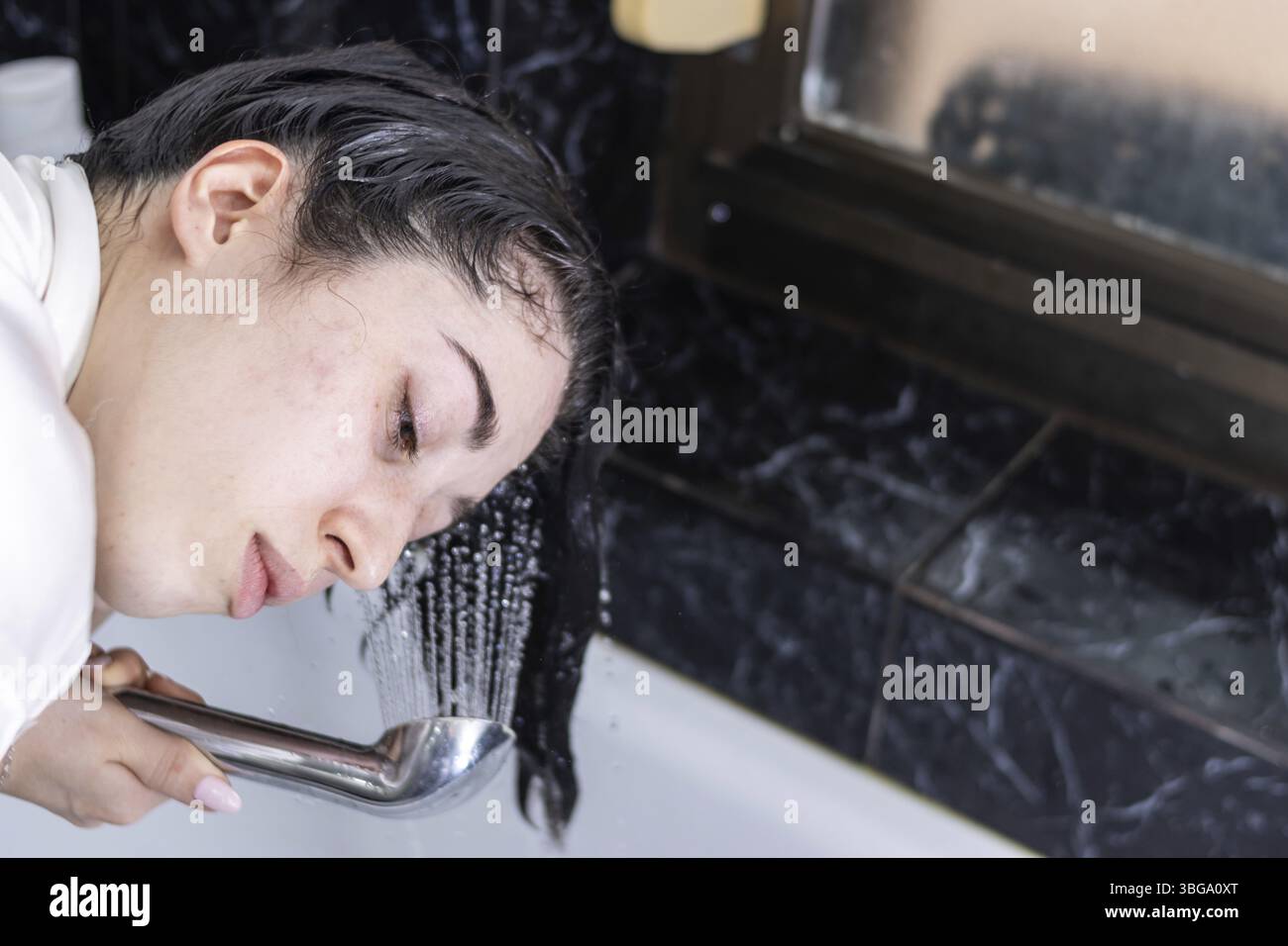 Woman washing her head with the shower. daily routine body care and ...