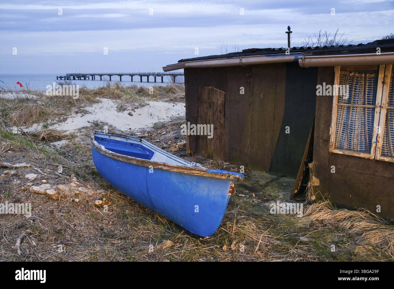 Frontal wide angle view of an old blue rowing boat at a weathered ...