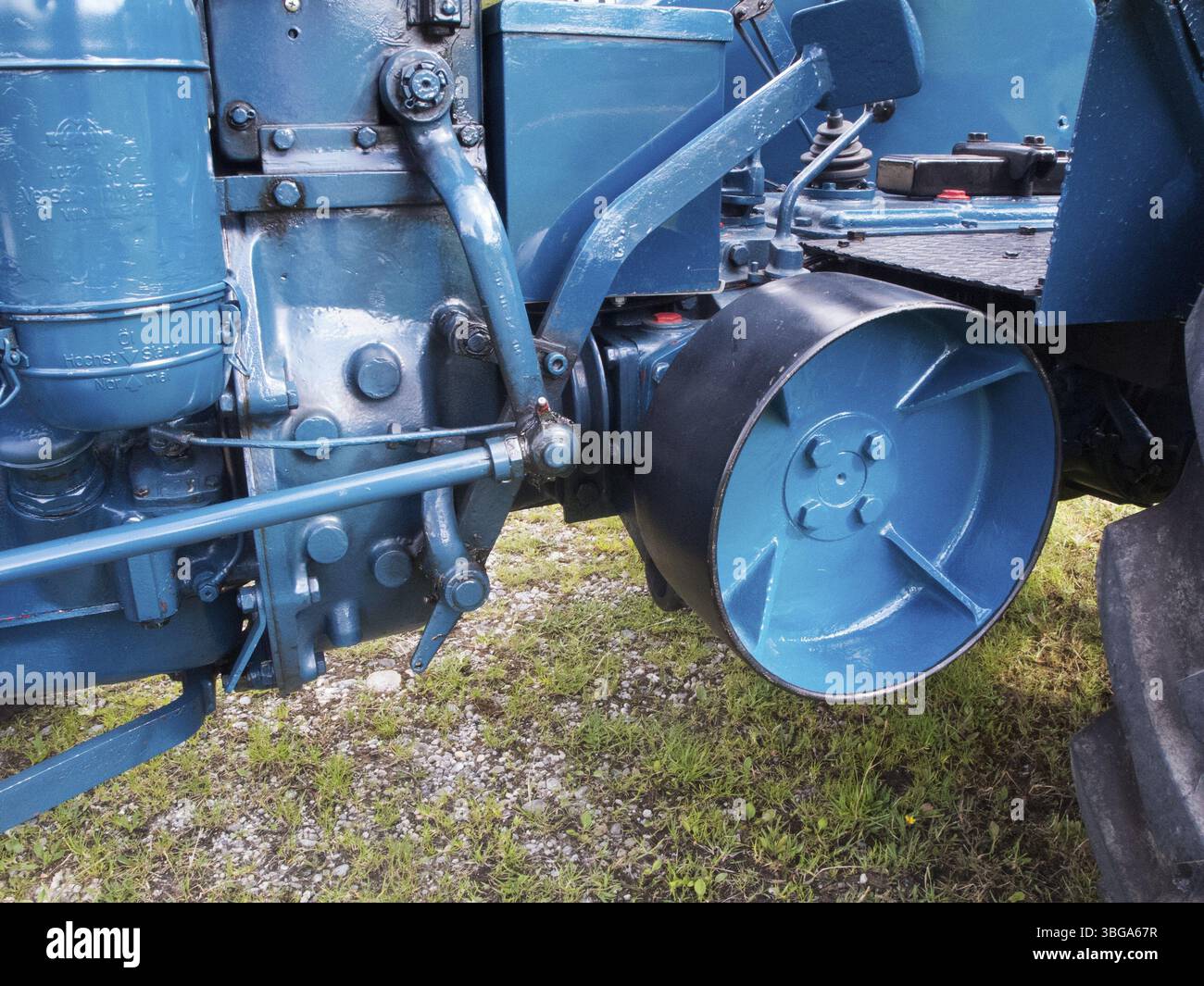 Partial view of an old and restored tractor in blue with a view of the ...