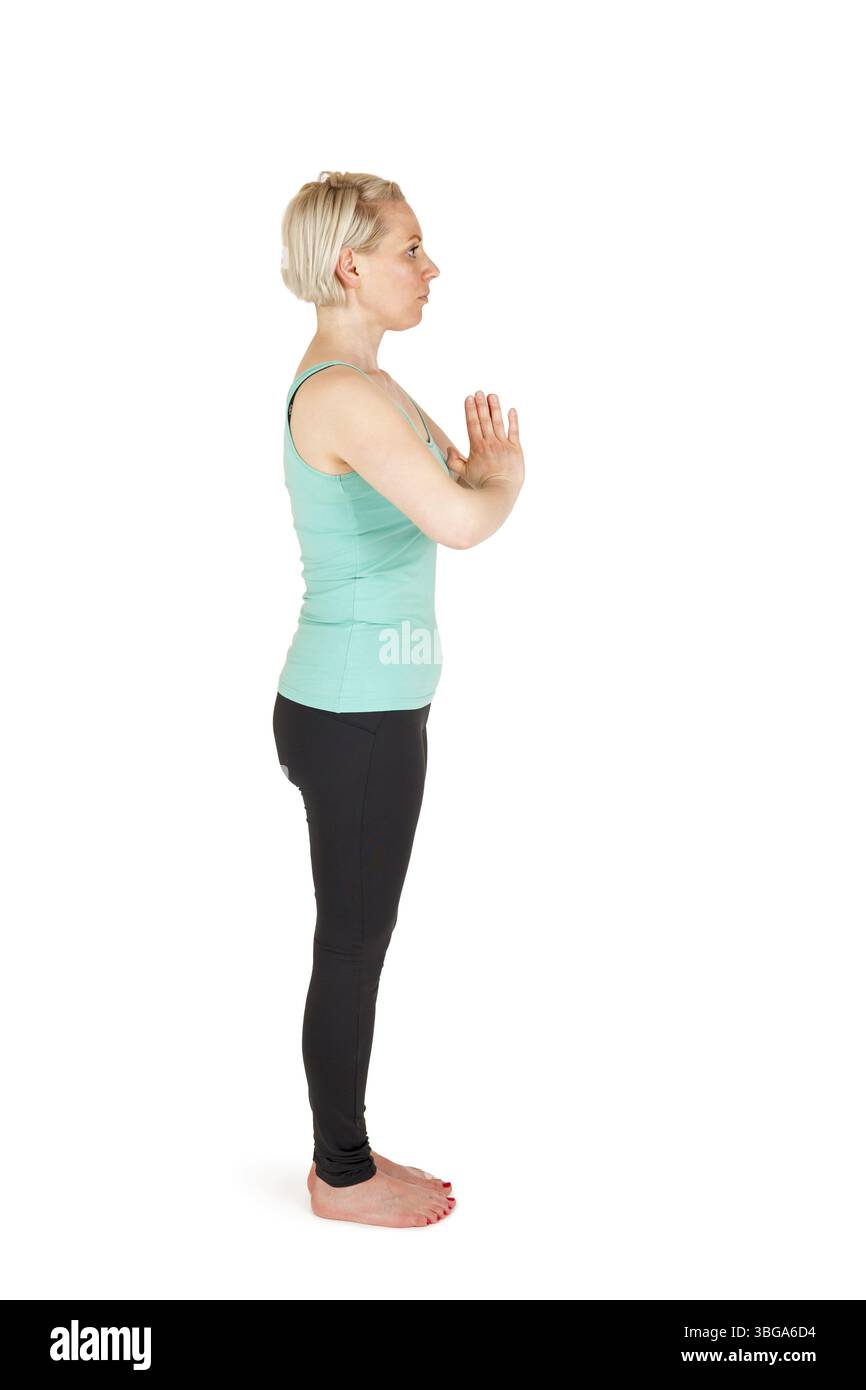 Full body view of a young blonde woman doing yoga exercise Standing ...