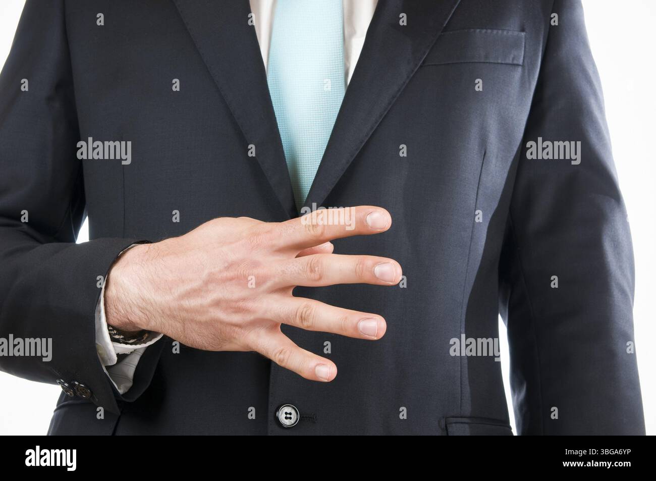 Chest-and-belly view of a young man in a black suit with his right hand ...