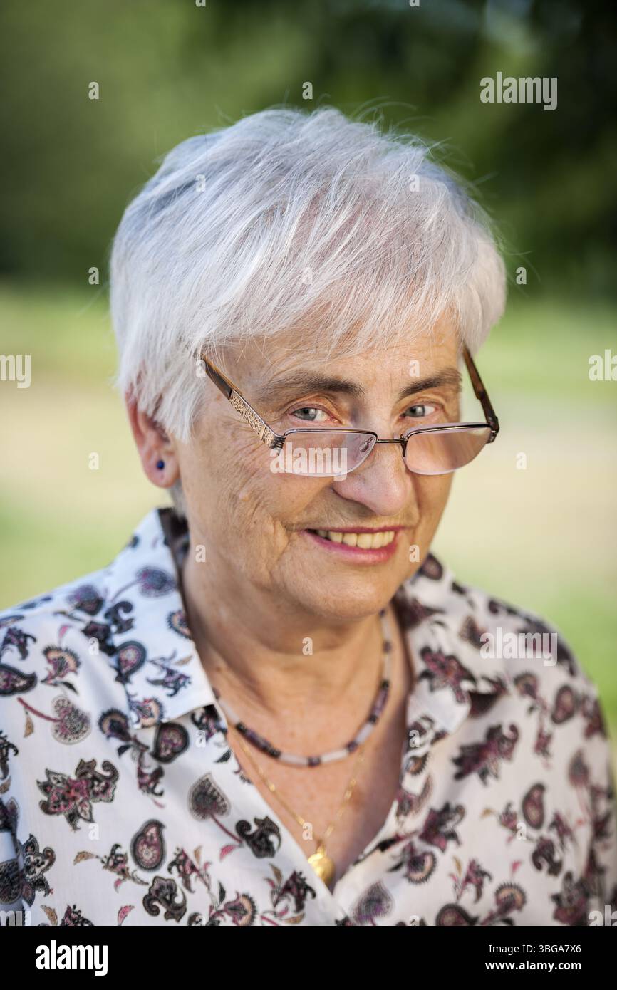 Head portrait of a 79-year-old woman with white hair against the ...