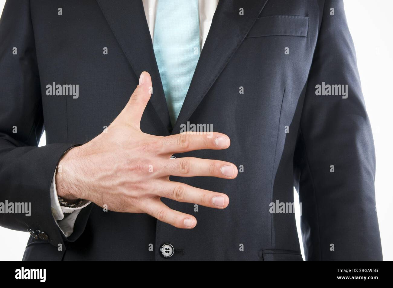 Chest-and-belly view of a young man in a black suit with his right hand ...