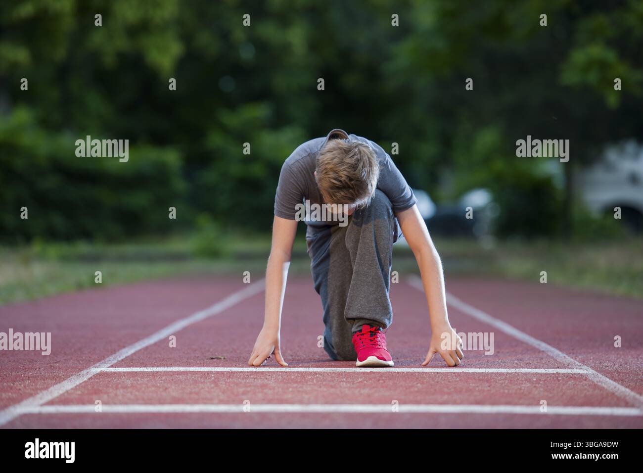 Low frontal full body view of a young male teenager in a low start ...