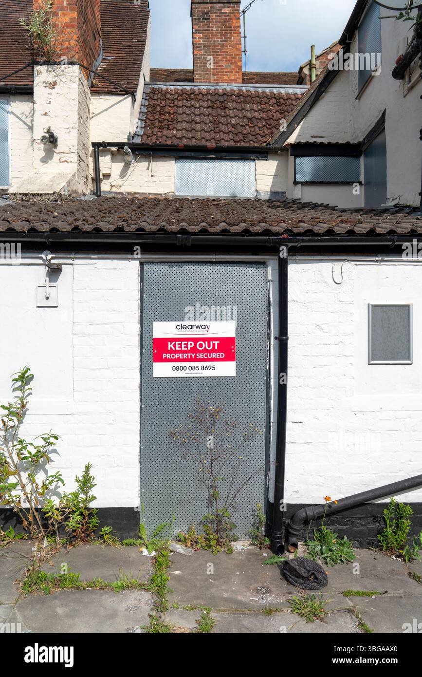 Entrance door to empty building secured by sheet metal plate with keep ...