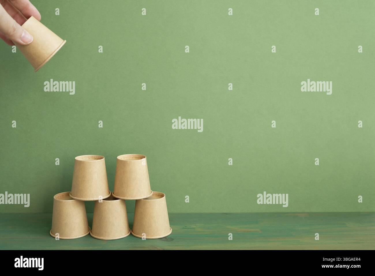 Pyramid stack of brown cup on wooden table. green background. business ...