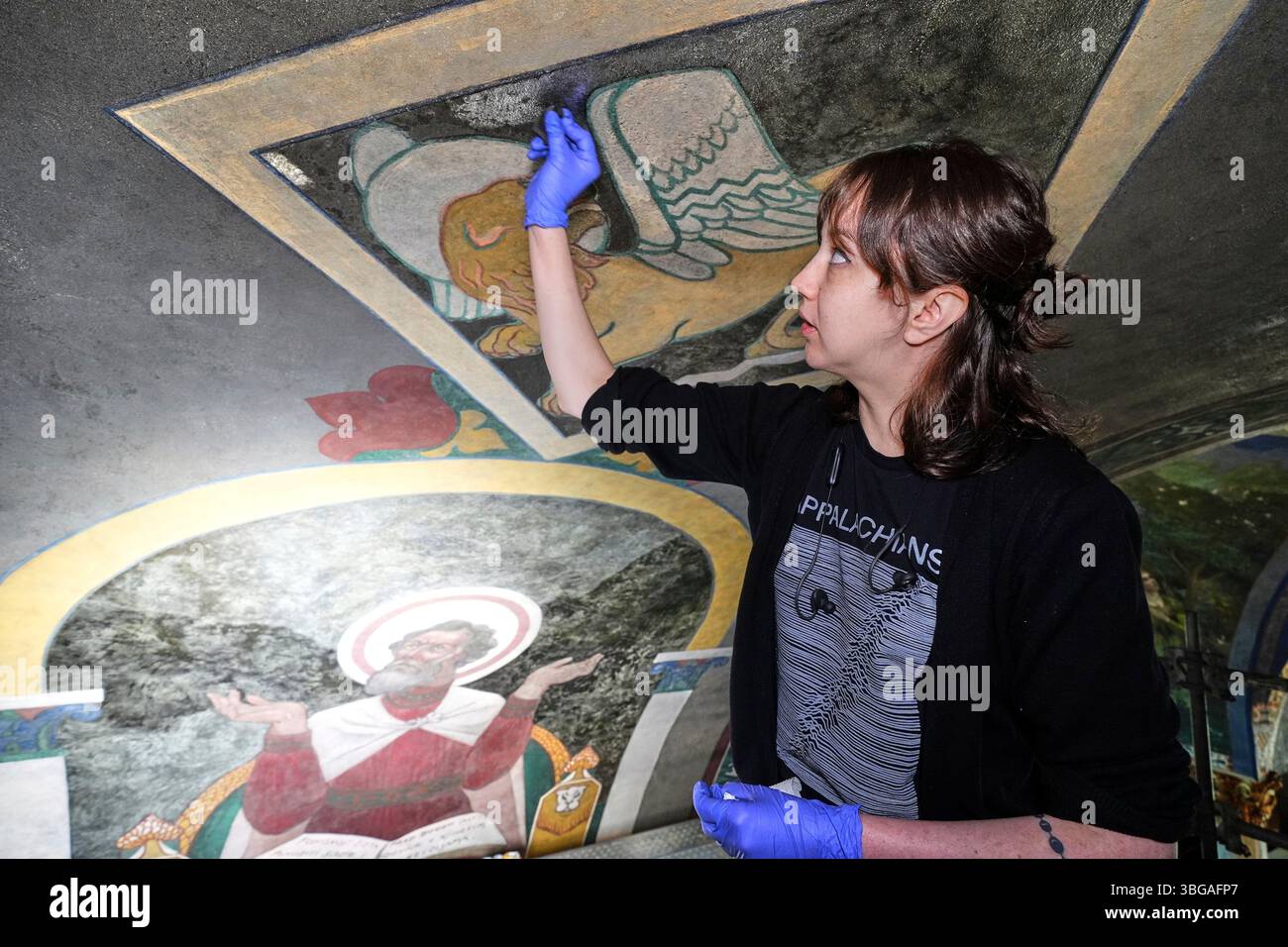Standing on a 32-foot-tall scaffold, art conservator Kate Pirelli works ...