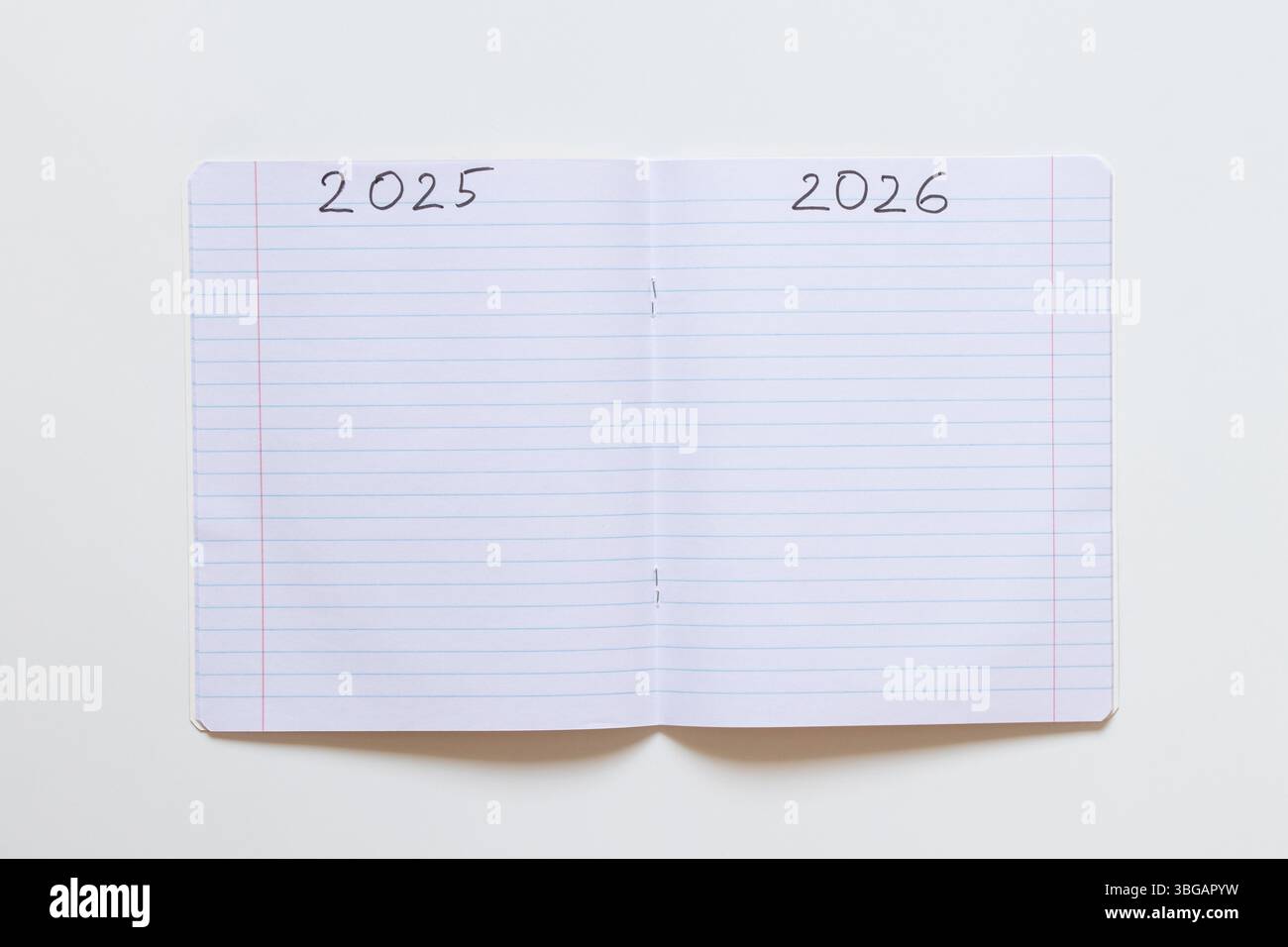 Open notebook with years 2025 and 2026 written on white background ...