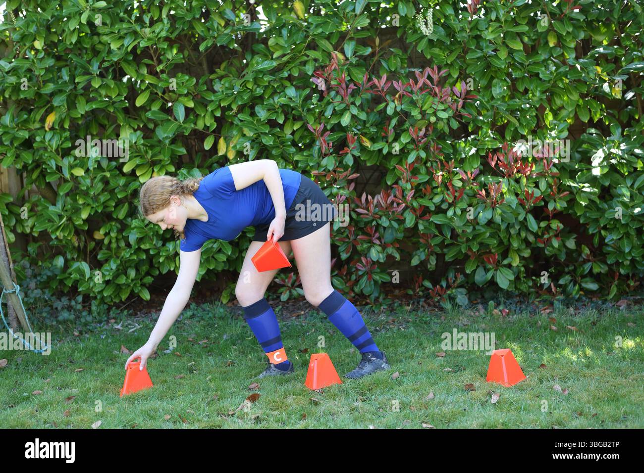 Girl sets out plastic cones for football drill dribbling soccer Stock ...
