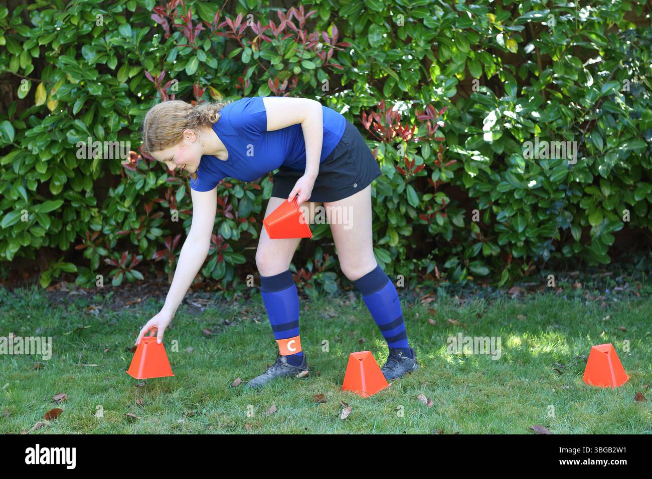 Girl sets out plastic cones for football drill dribbling soccer Stock ...
