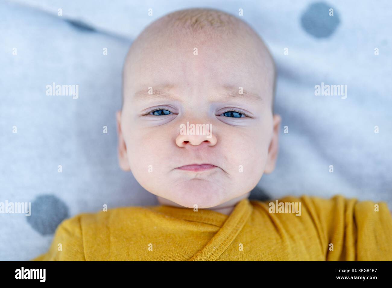 Description: Grinning infant baby with blue eyes and a cute, cheeky ...