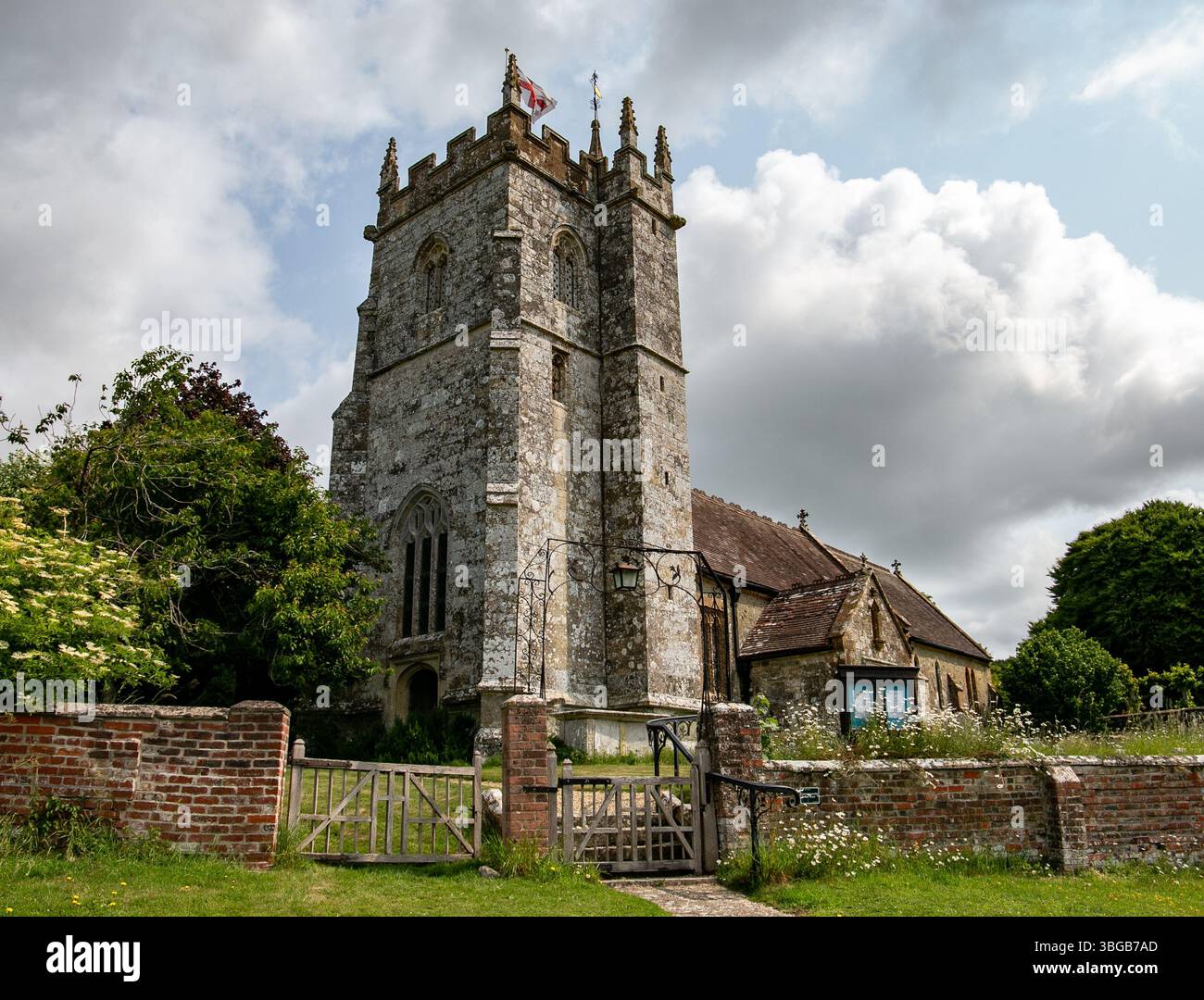 Historic stone church with a tall tower and an English flag under a ...