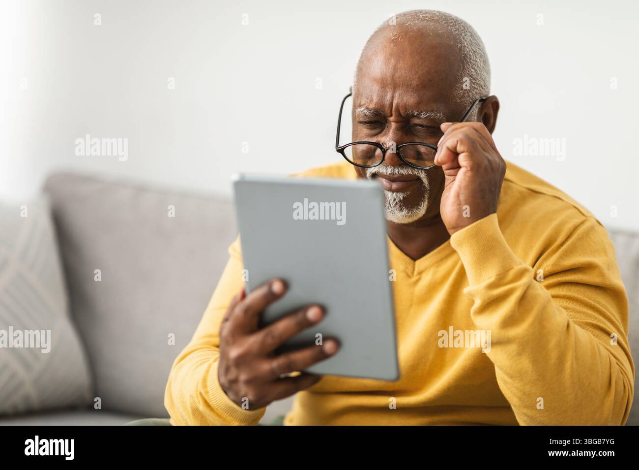 Senior Man With Poor Eyesight Using Tablet Squinting Eyes Indoor Stock ...